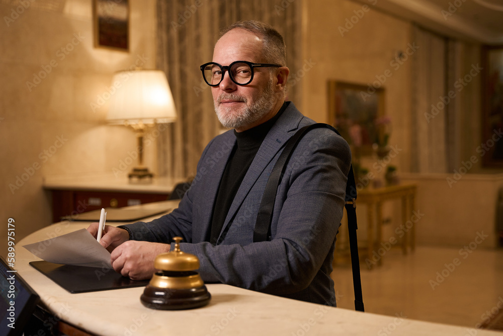 Elderly man arrived at hotel and fills out registration papers Stock ...