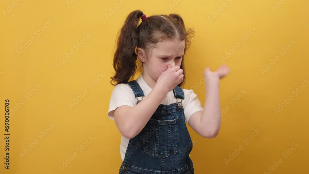 Portrait of little girl kid wearing casual clothes smelling something ...