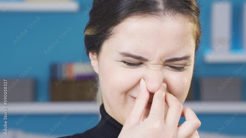 Video Stock Disgusted by the smell, young woman covers her nose ...