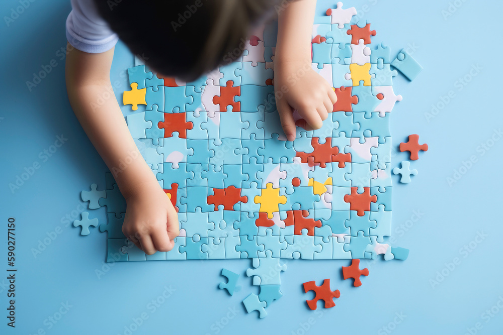 Top view hands of an autistic child arranging a soft blue puzzle ...