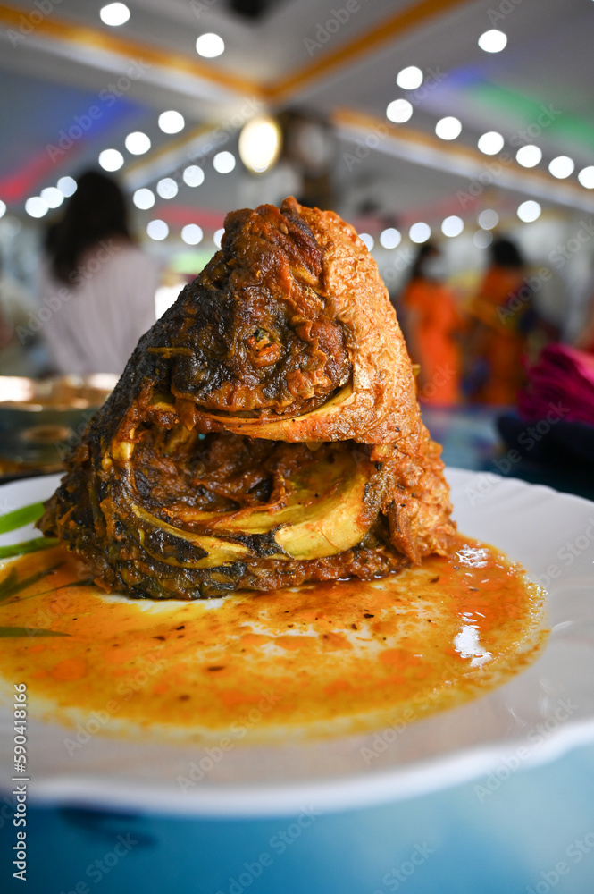Catla (Katla) fish head curry in a bowl at restaurant or home. Macher ...