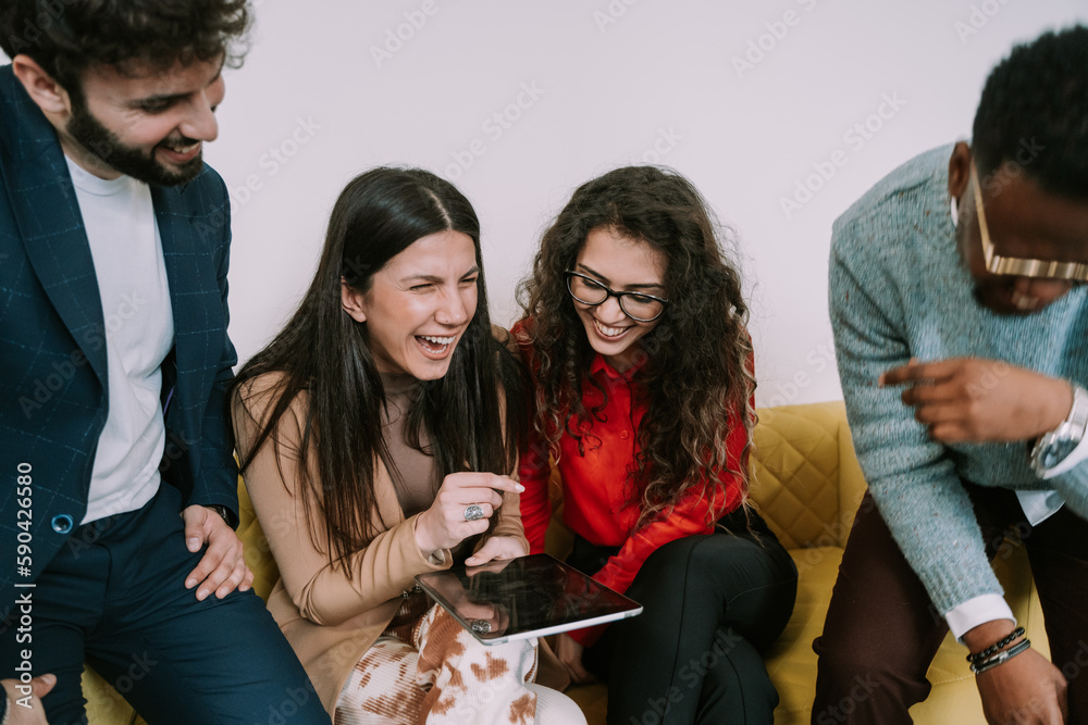 Multiracial colleagues burst out laughing after joking each other while ...