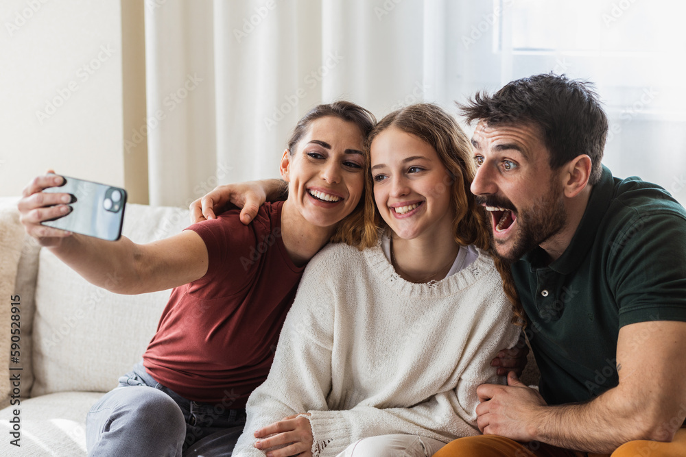 Young parents taking a photo with their daughter, father making goofy ...