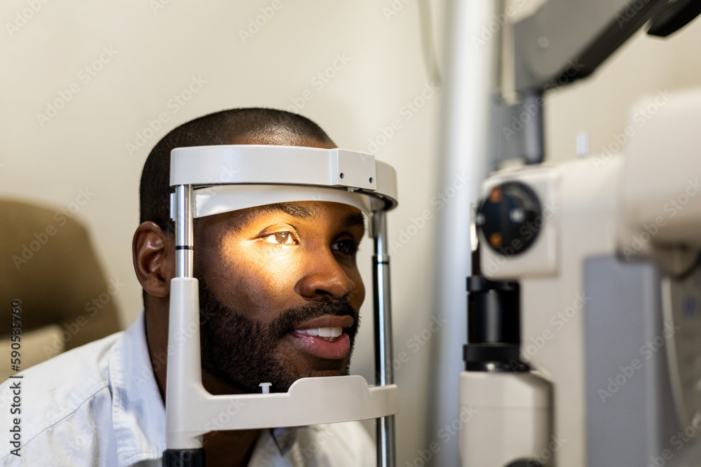 Photo & Art Print Examination of a dark-skinned man with a slit lamp ...