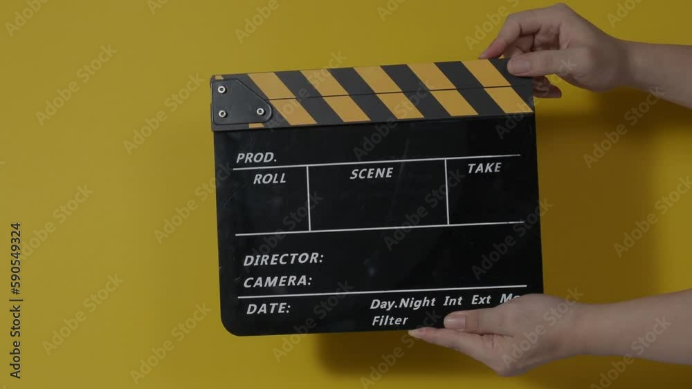 Film slate or Movie clapperboard hitting in front of cinema camera ...
