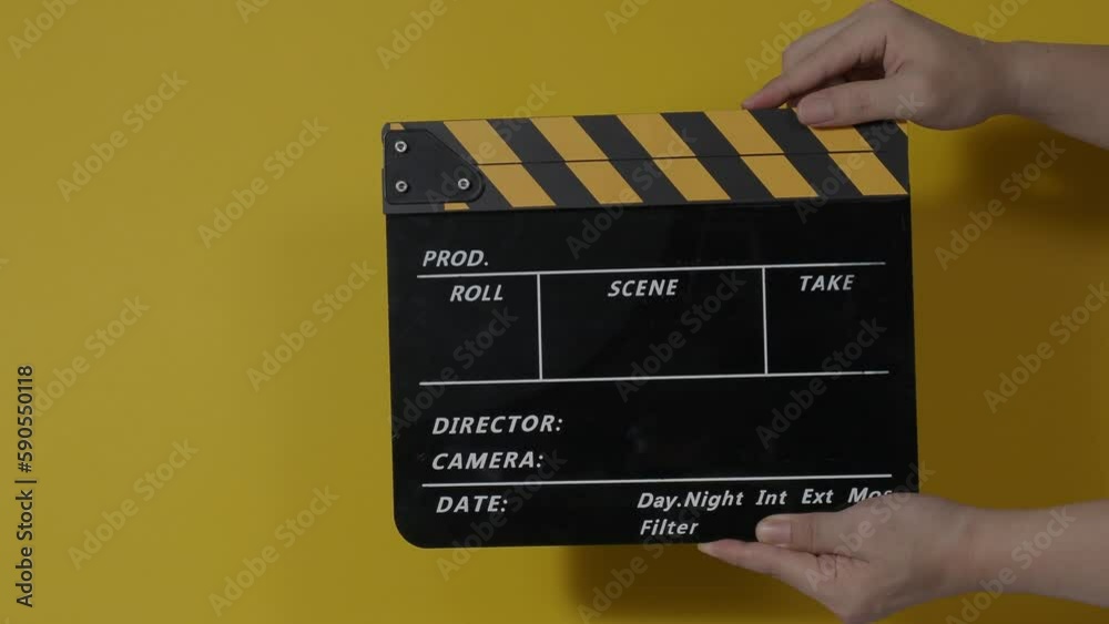 Film slate or Movie clapperboard hitting in front of cinema camera ...