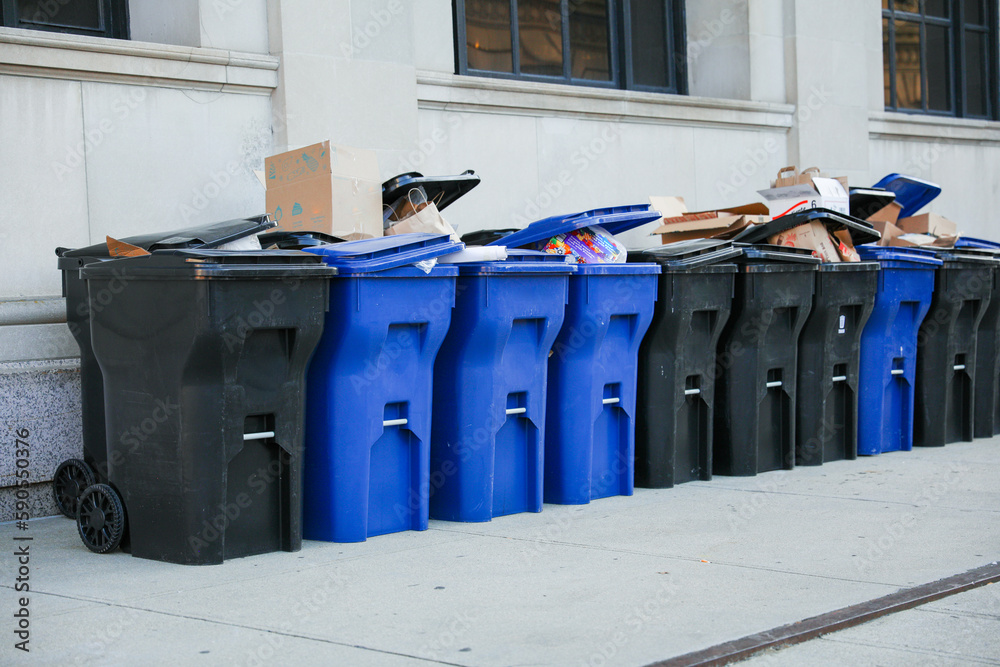 overflowing trash can next to recycling bins symbolizes the importance ...