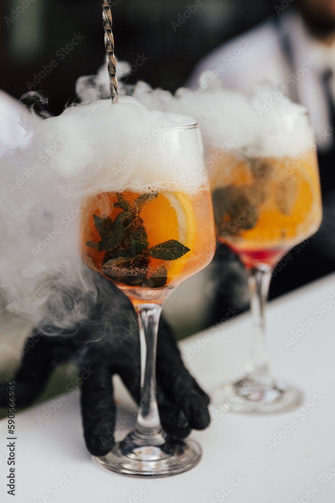 Bartender making Aperol spritz cocktail. Interferes prosecco and Aperol ...