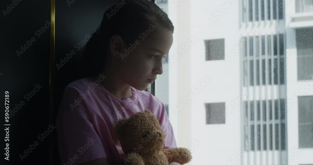 Cute little girl portrait child is sad in her room with a toy in her ...