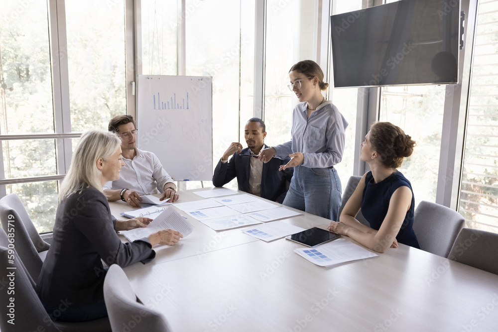 Young business leader woman talking to colleagues, offering ideas for ...
