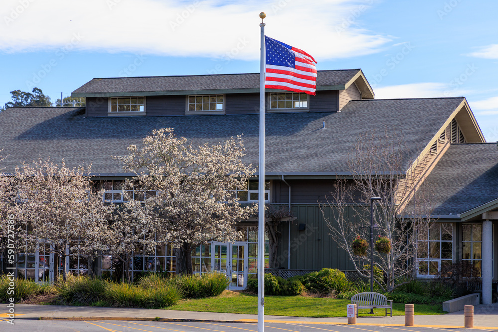 American flag flies over small town community center building on sunny ...