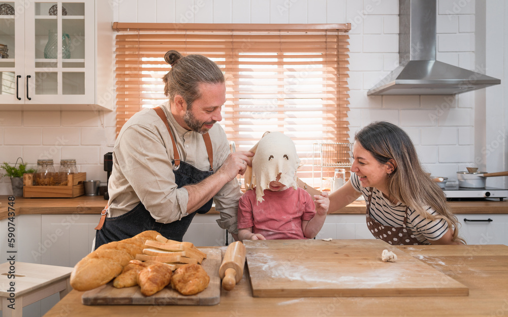 Family together in the kitchen. Family making cake with his toddler son ...