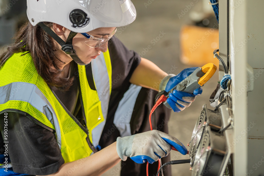 Woman Electrician engineer work check tester measuring voltage and ...