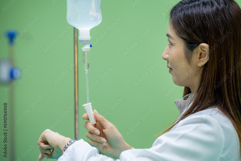 Woman doctor monitor Adjust the drip rate feed of saline dripping ...