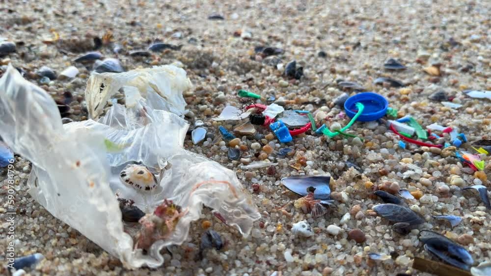 Small plastic pieces lying on sand on beach, illustrating the problem ...