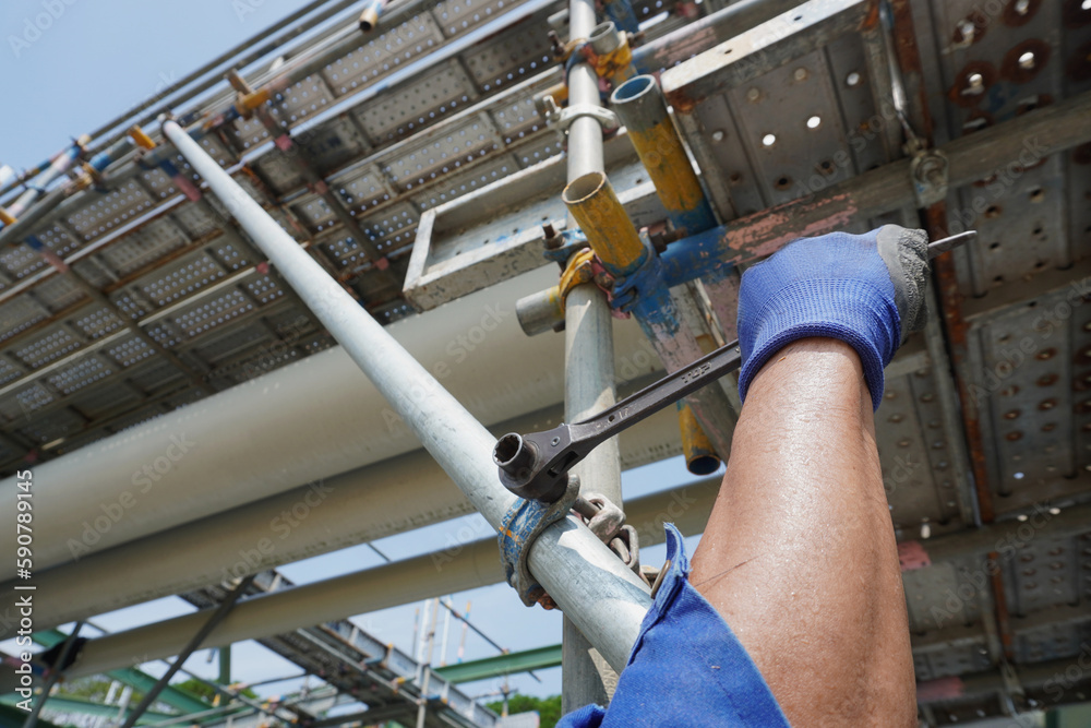 Worker's hand holding a wrench to installation scaffolding work for ...