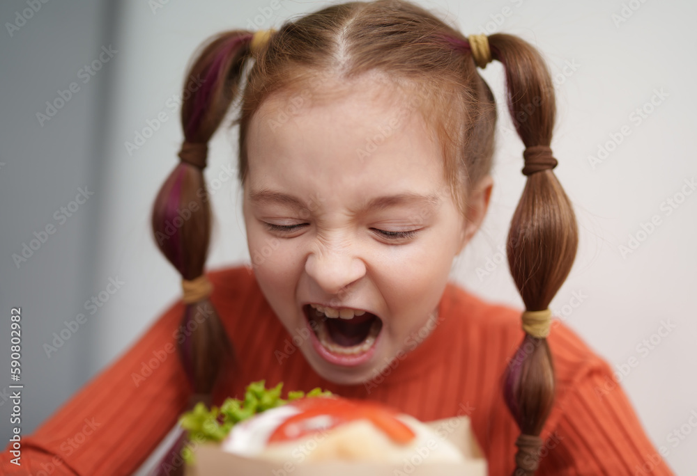 Funny white girl biting a sandwich. Portrait of cute 9 year old kid ...