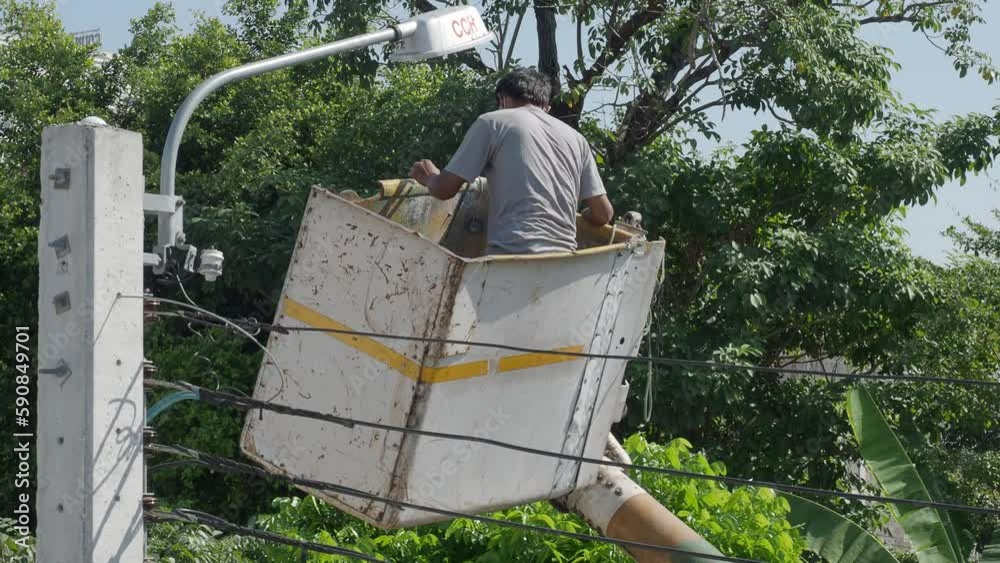 Worker on height lifting platform installing new street light bulb ...