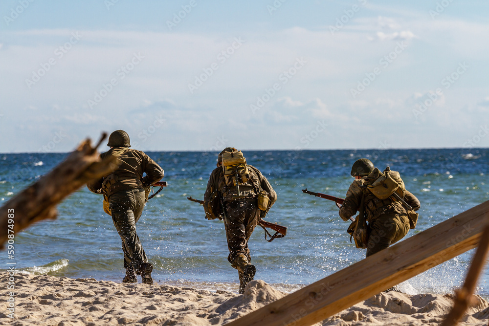 Historical reconstruction. World War II infantry division soldiers run ...