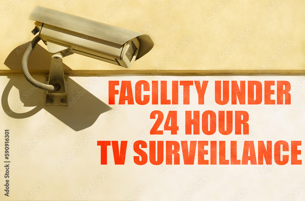 A CCTV camera is installed on the wall of the building, next to it is ...