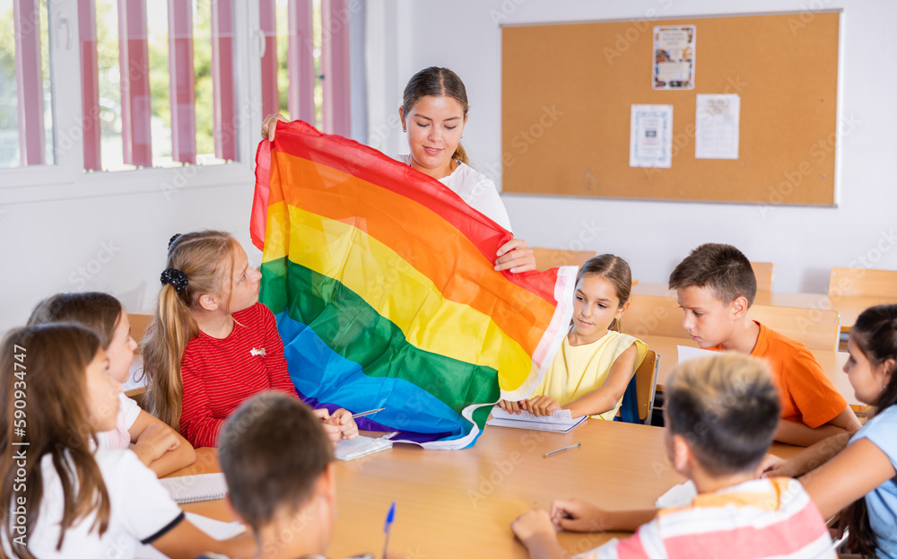 Portrait of smiling young female teacher conducting lesson for tweens ...