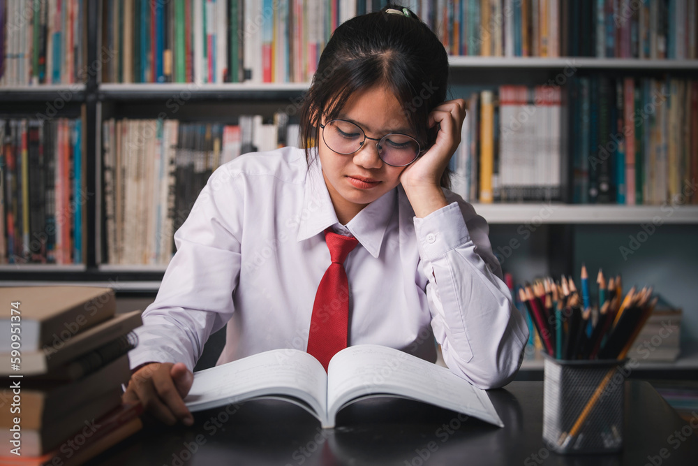 Unhappy teenage Asian girl student in school uniform wearing glasses ...