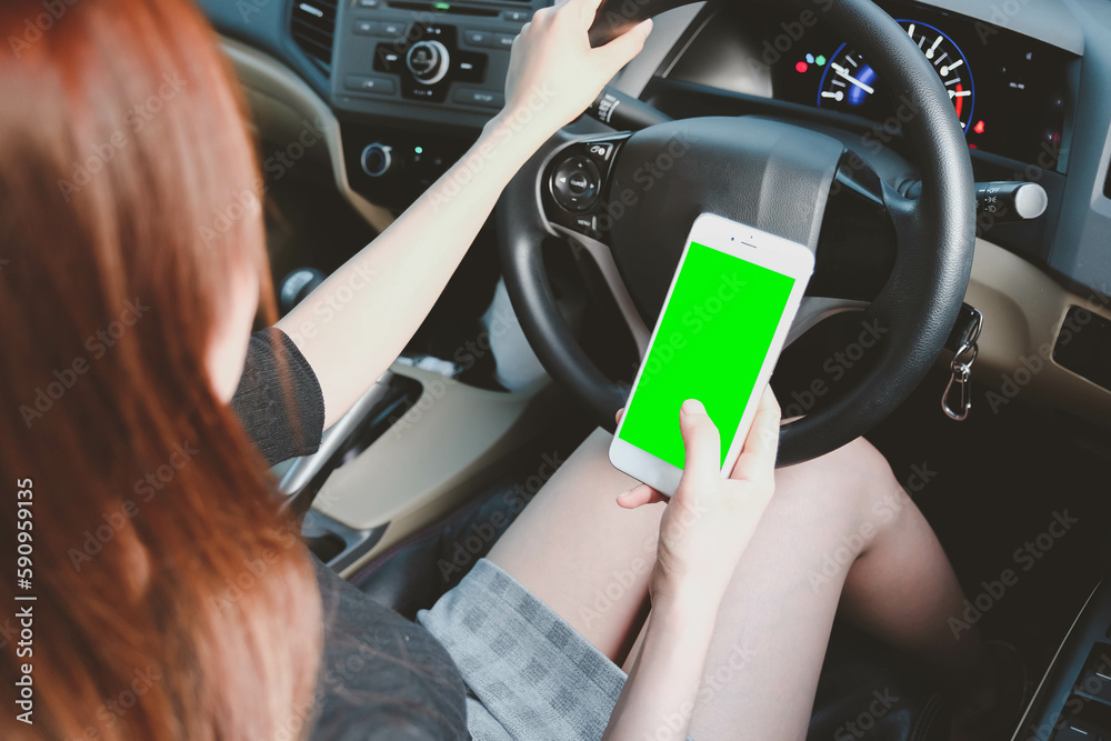 Mockup image of a woman holding and using mobile phone with blank green ...