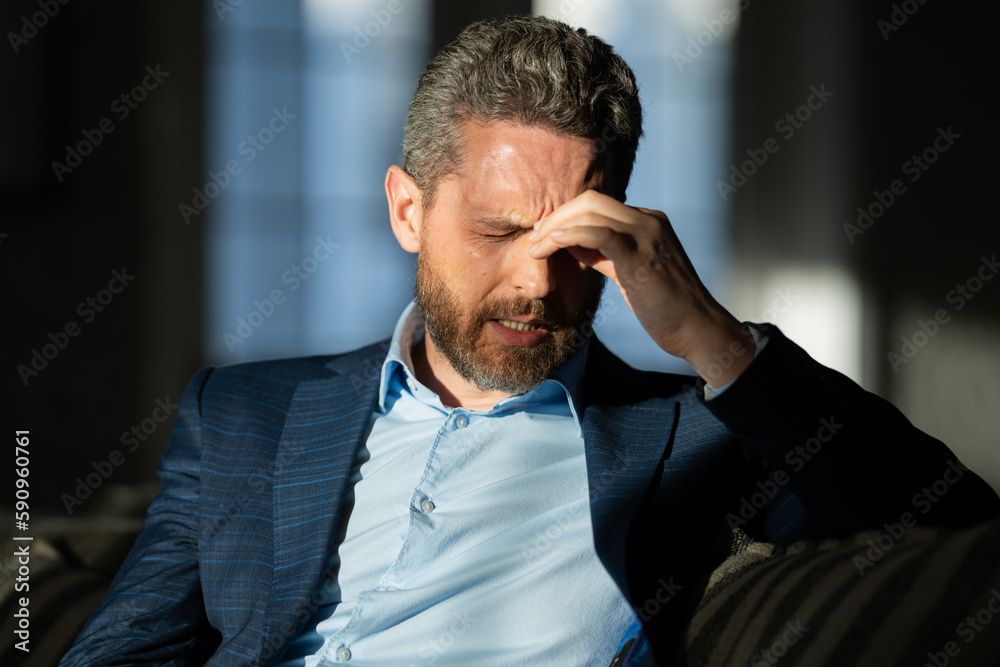 Tired man suffering from headache, touching head, relieving pain ...