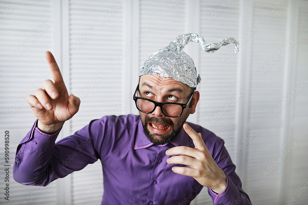 Bearded funny man in a cap of aluminum foil. Concept art phobias ...