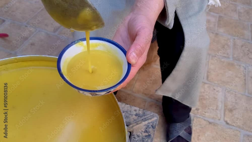 Close up shot of serving a golden sweet juicy drinking dessert halwa or ...