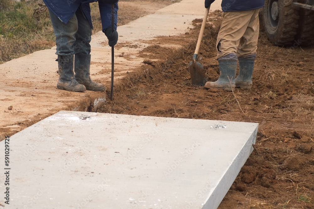 Foto de Two man construction workers with shovels dig the ground to lay ...