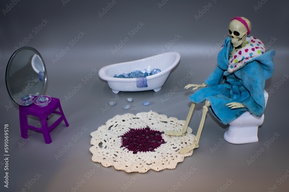 Skeleton sitting on the toilet in the bathroom and preparing to take a ...