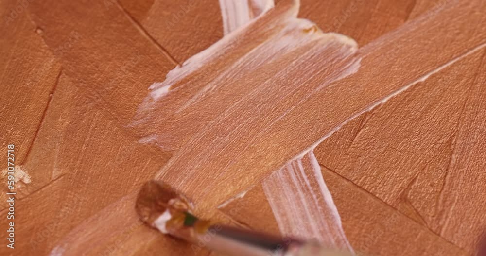 drawing lines with gold paint on canvas with an artistic brush, using ...