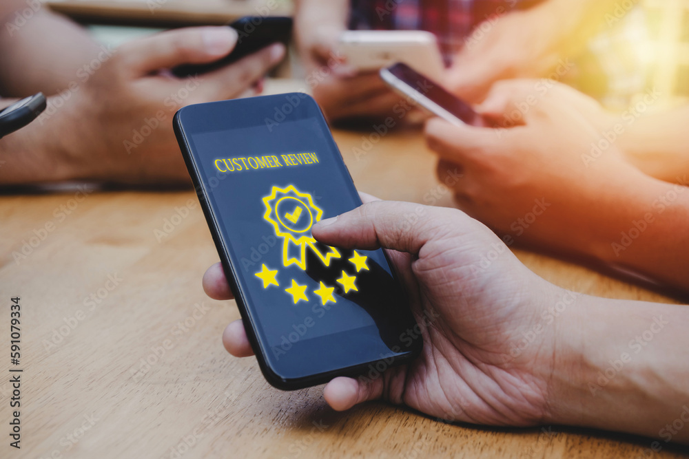 people hand touching mobile smart phone with graphic five star button ...