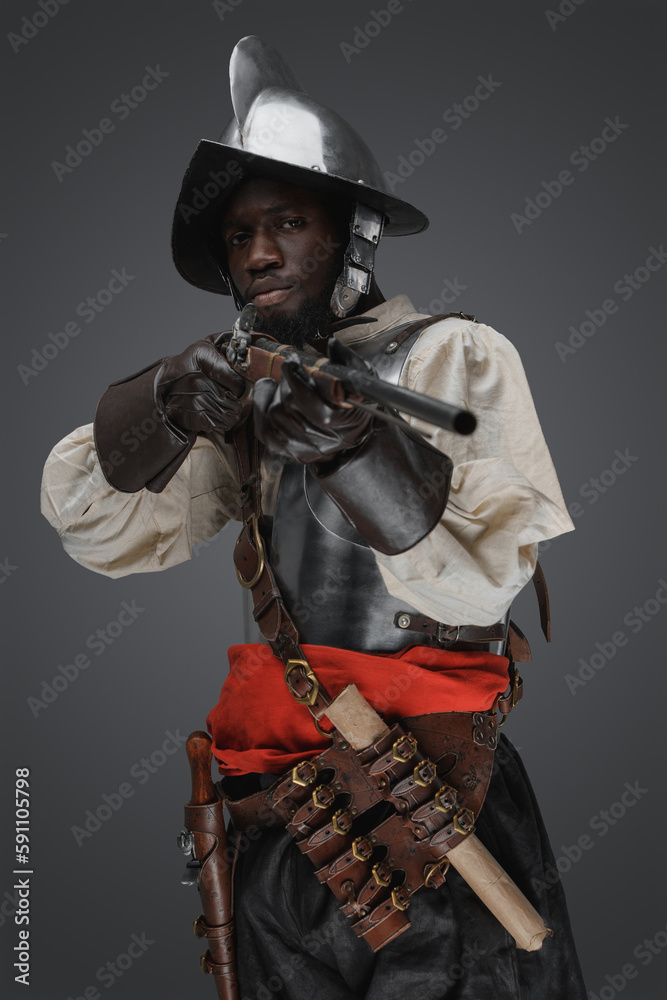 Shot of medieval soldier dressed in steel armor and helmet aiming ...