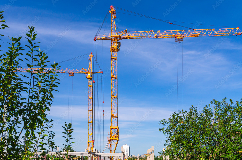 Foto de High-rise tower cranes that build houses can be seen behind the ...