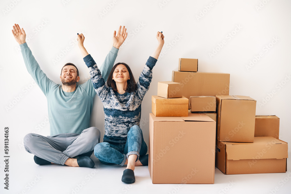 Happy young couple celebrate moving to new home with raised hands ...
