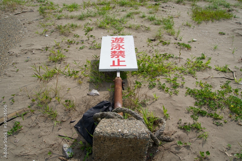 No swimming sign overturned on the beach Japanese translation: No ...