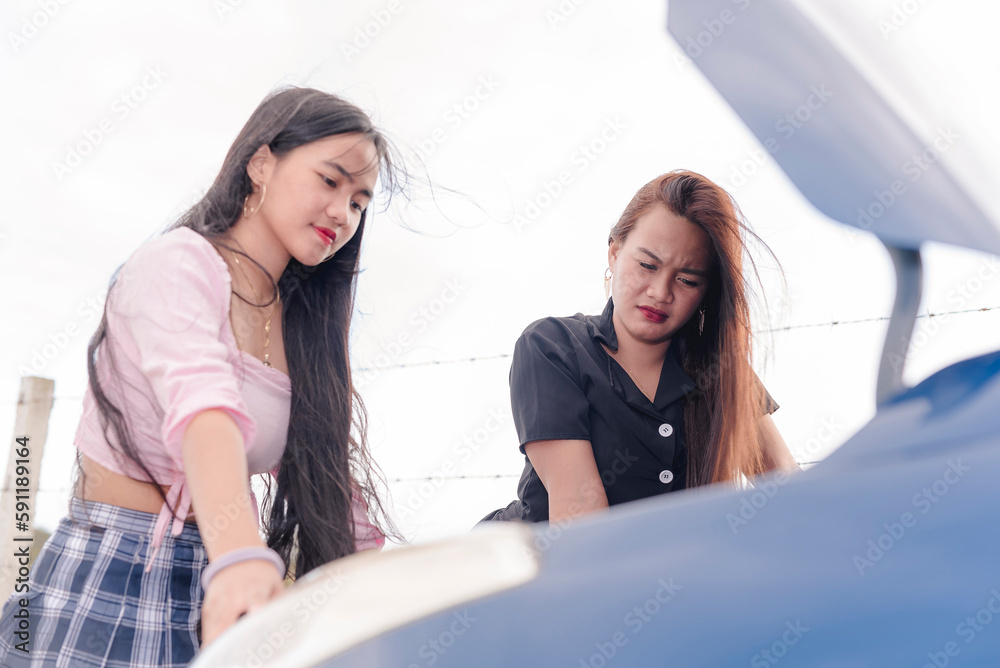 Two women were stranded on the side of the road while the hood of the ...