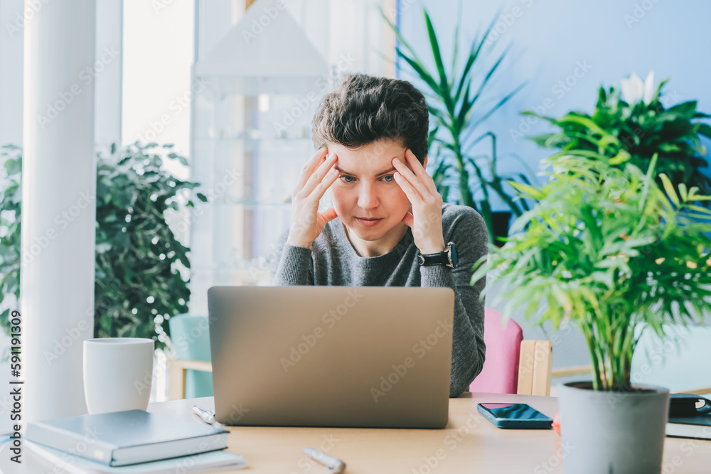 Middle aged shocked business woman sitting in front of laptop looking ...