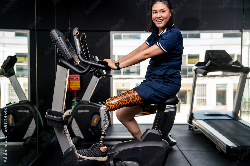 Young woman with prosthetic legs and workout clothes doing exercises on ...