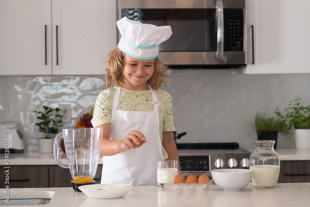 Chef kid boy baking on the kitchen. Child chef cook prepares food at ...