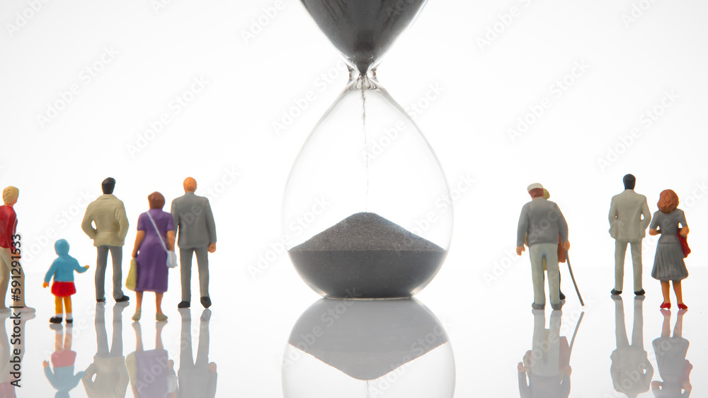 miniature people. different people are walking next to the hourglass on ...