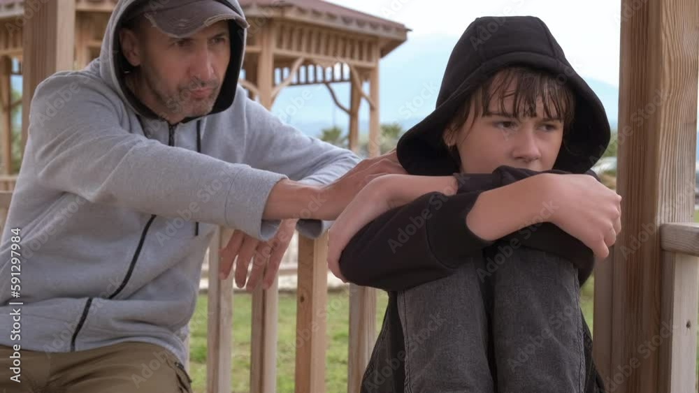 Video Stock Dad calm her child on bench. A view of sad dad try to calm ...