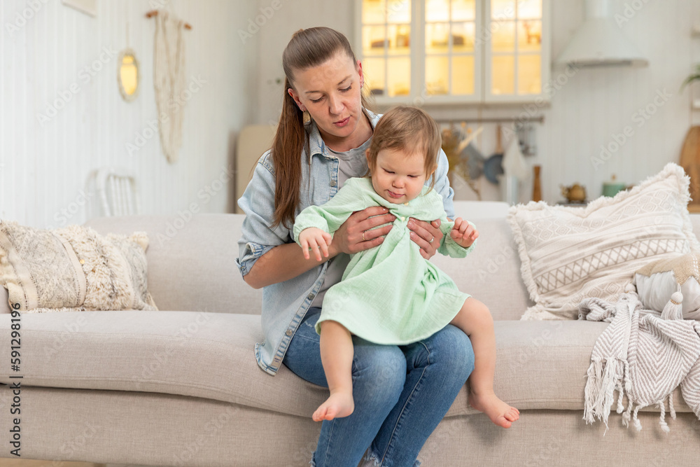 Happy family at home. Mother lifting in air little toddler child daughter. Mom and baby girl ...