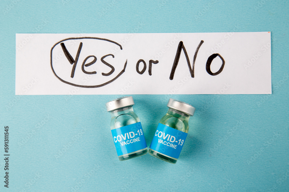 top view antivirus vaccine with yes or no notes on a blue background ...