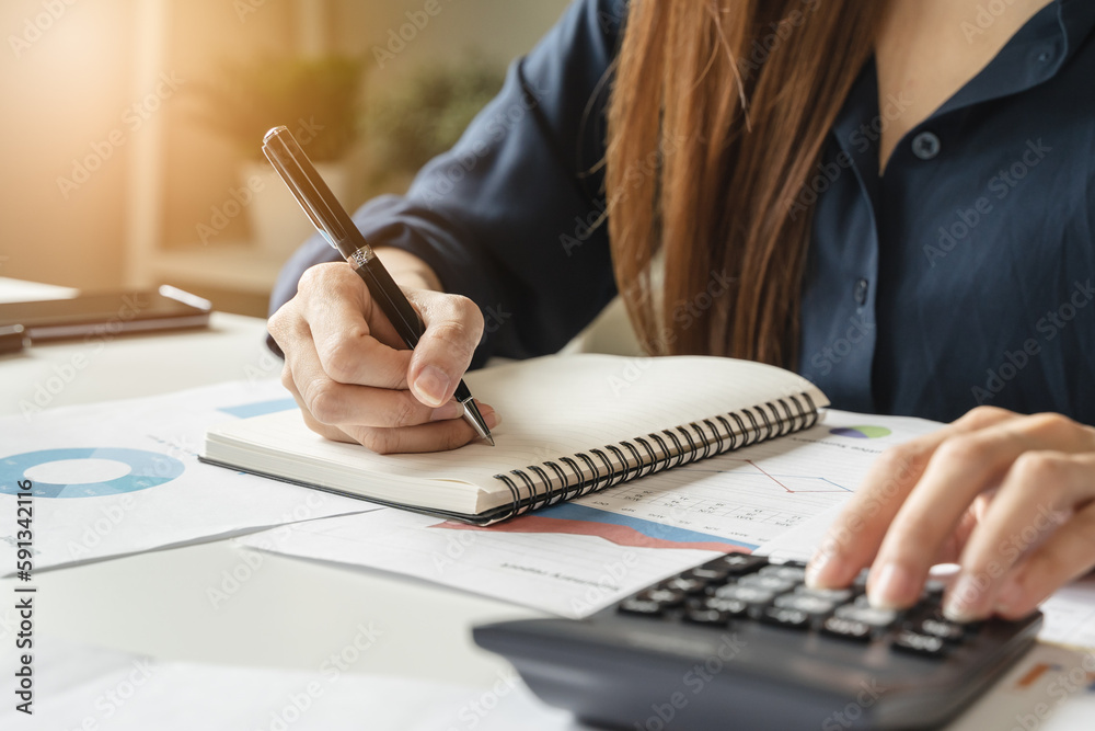 Women business people use calculators to calculate the company budget ...