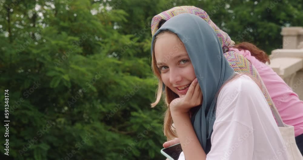 Religious smiling blonde cute muslim girl in grey headscarf looking at ...