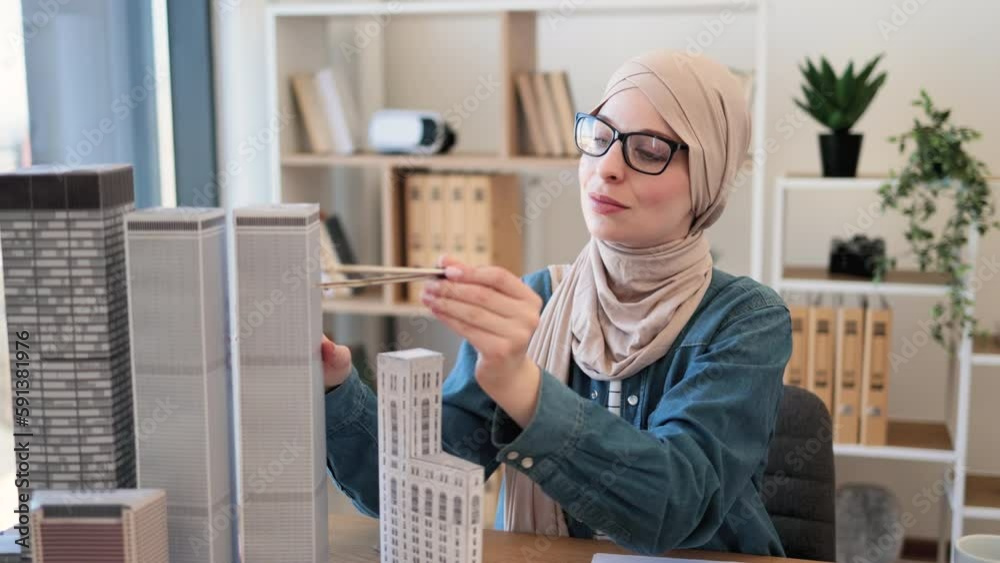 Charming arabian lady in hijab and casual clothes holding drafting ...