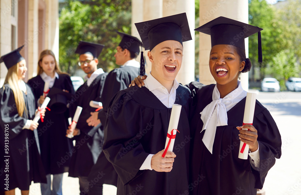 Happy smiling caucasian man afroamerican woman in graduation gown and ...